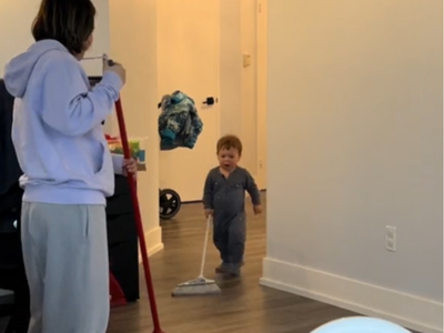 Baby mimics mom's cleaning by doing the exact opposite