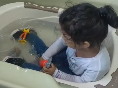 Toddler takes a bath with her new shoes on