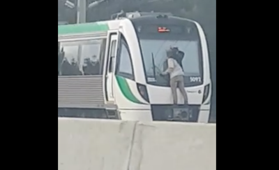 Man catches a ride on train's windscreen wiper